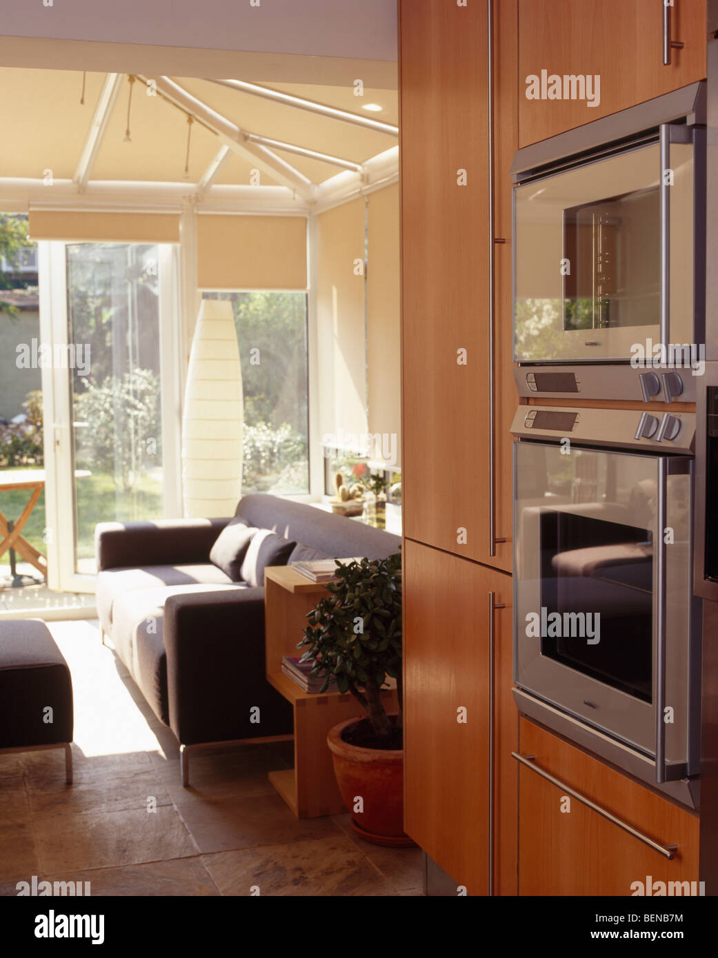 Stainless-steel eye-level ovens in modern open-plan kitchen and living ...