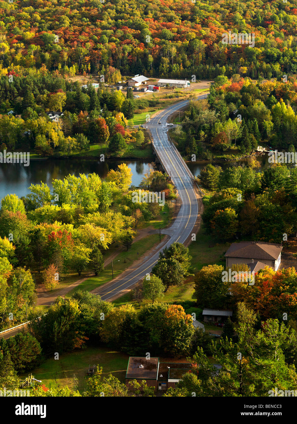 Aerial fall nature scenery of a winding road crossing the Lake of Bays ...