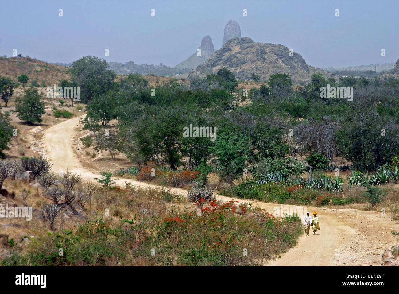 Indigenous people walking on dirt road and volcanic plugs / lava necks ...
