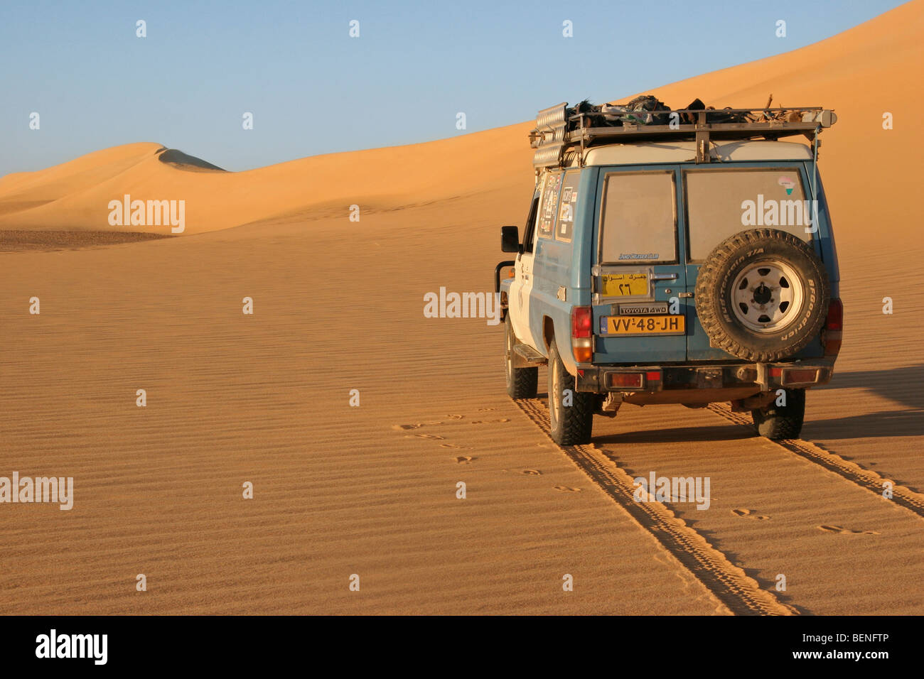Off-road four-wheel drive vehicle in the red sand dunes of the Western ...