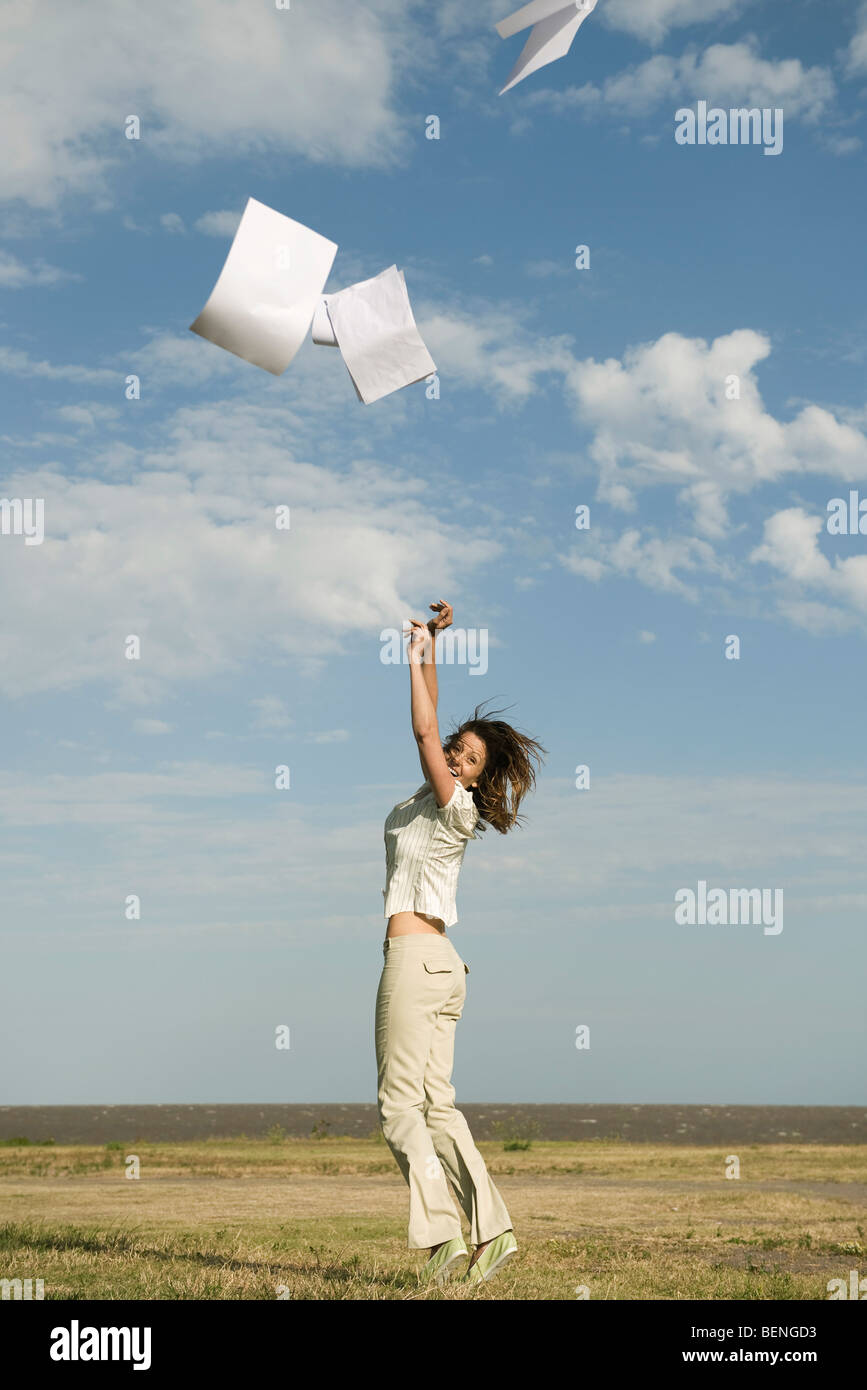 Woman outdoors tossing document into air Stock Photo - Alamy