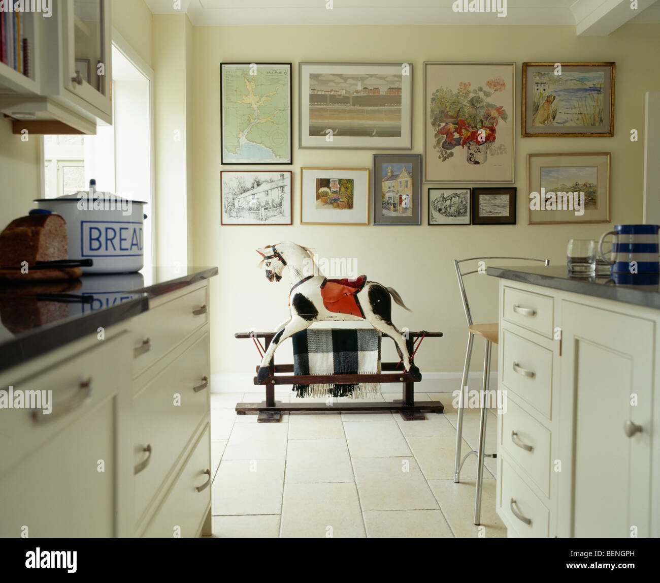 Rocking horse in modern white kitchen with ceramic tiled floor and ...