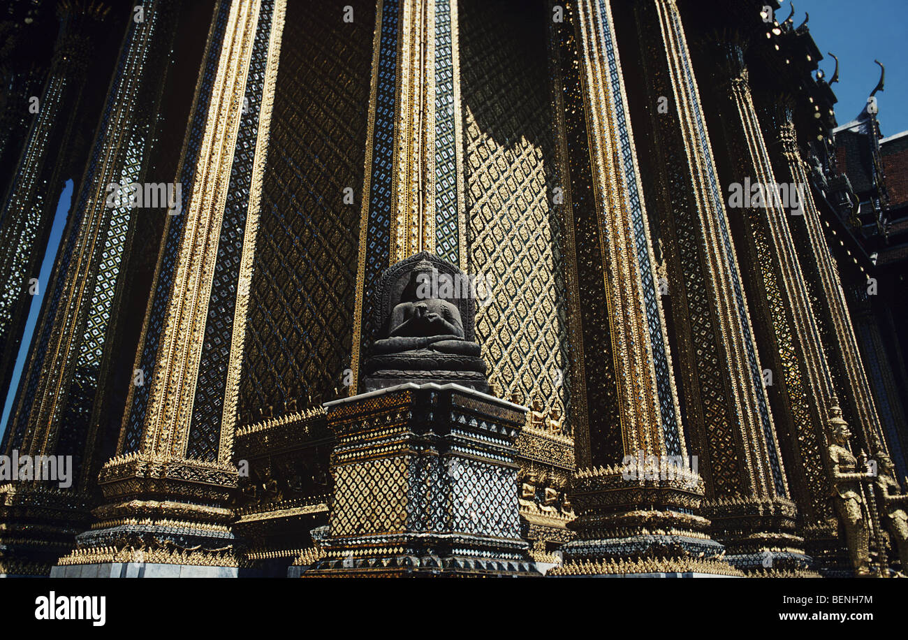 Small plain granite statue of seated Buddha on plinth in front of ...