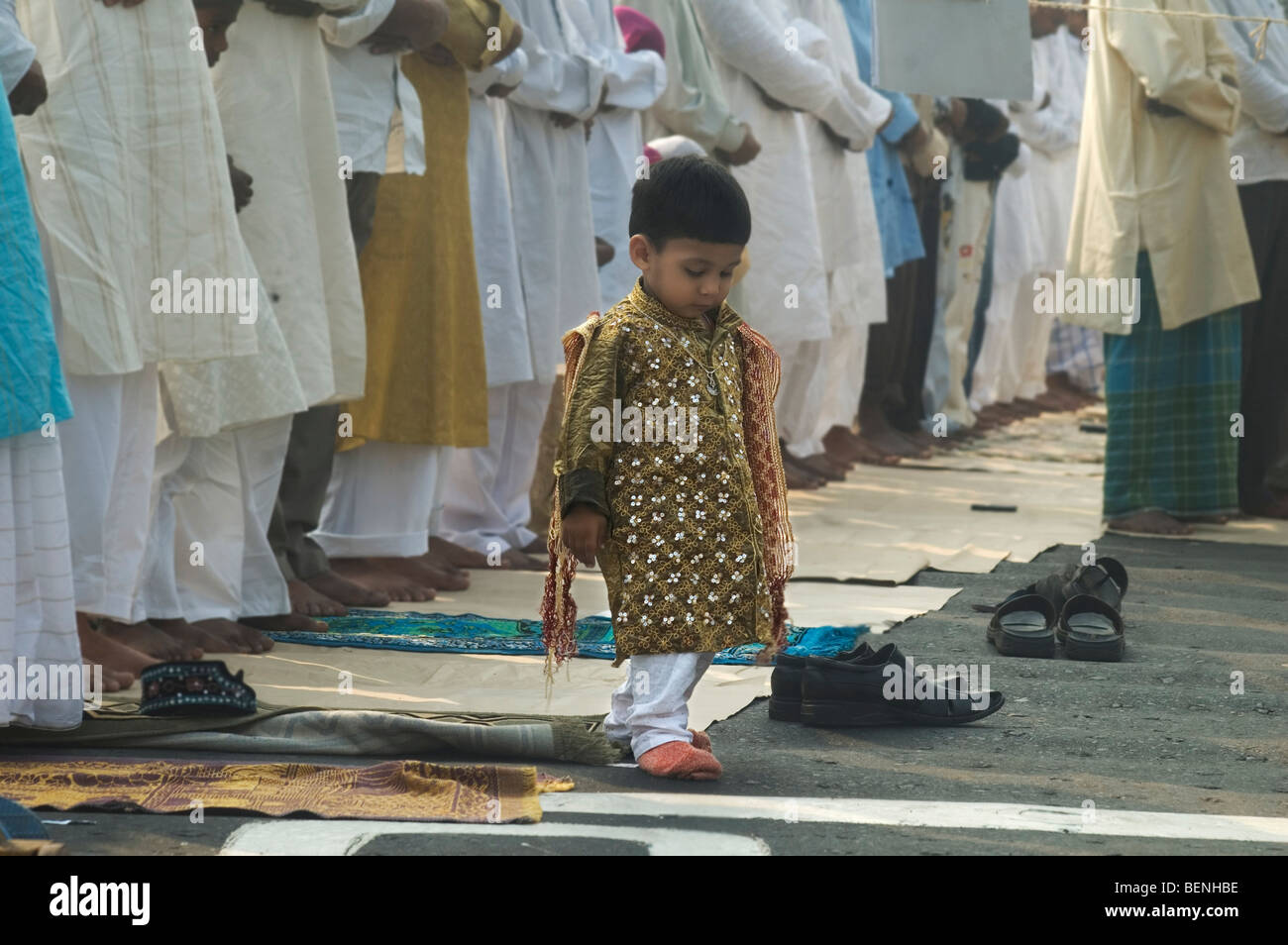 A little Muslim boy standing with elders at the Id prayers at Red Road ...