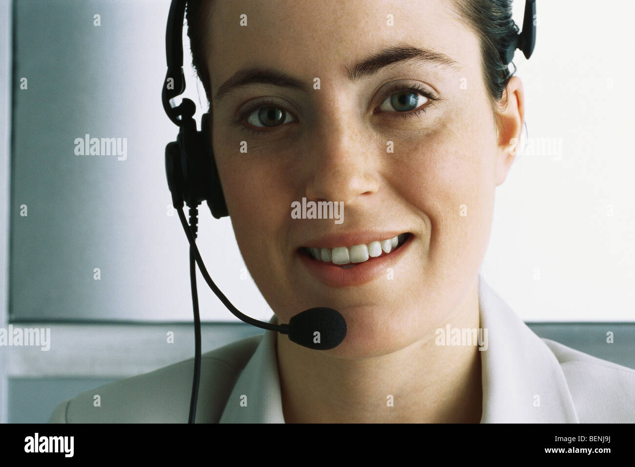 Customer service representative wearing headset, smiling at camera ...