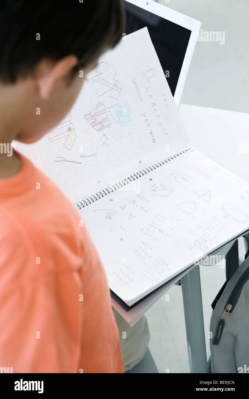 Elementary school student looking through notebook Stock Photo - Alamy