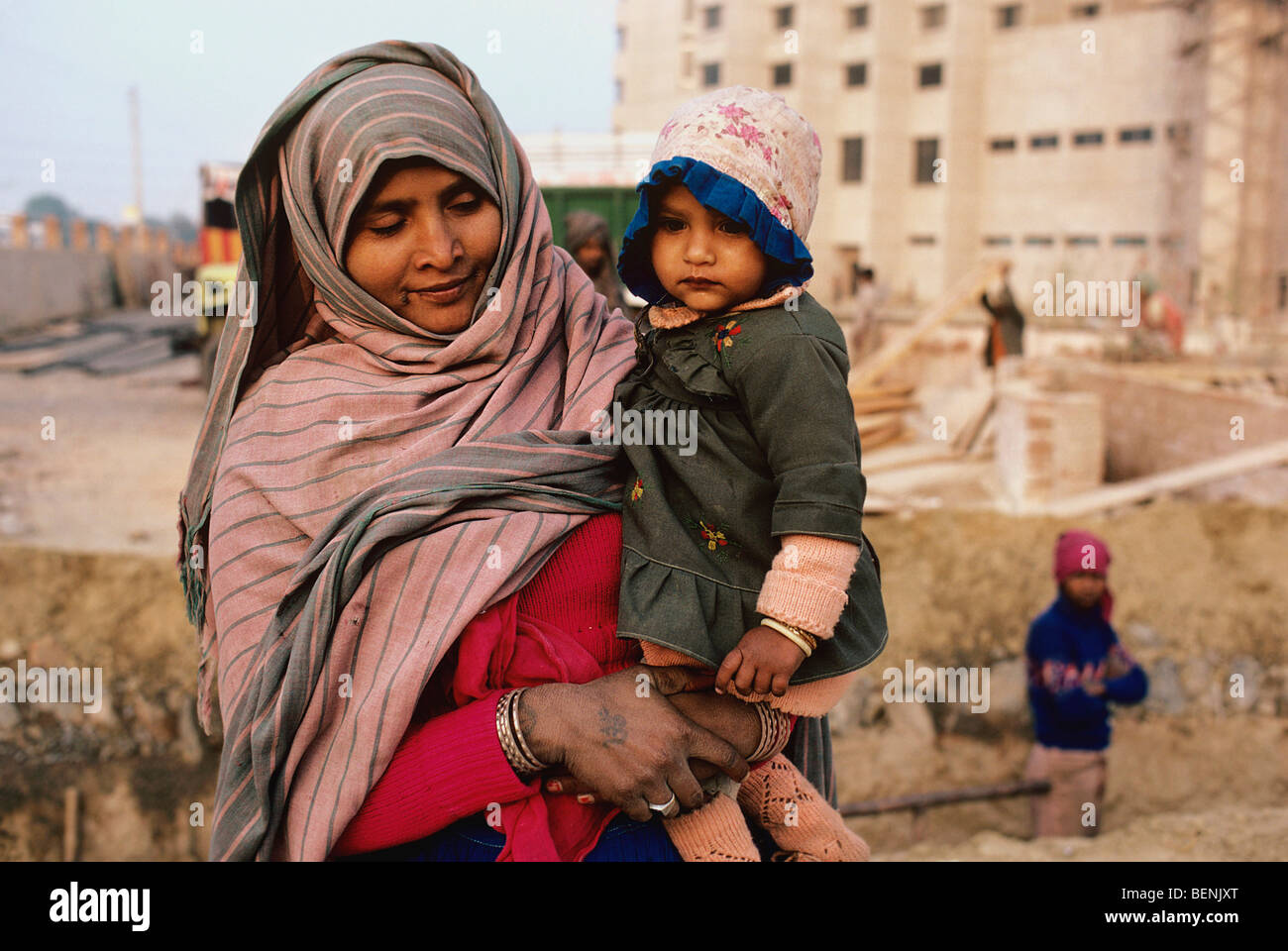 A female construction worker holding her child Delhi India Stock Photo ...