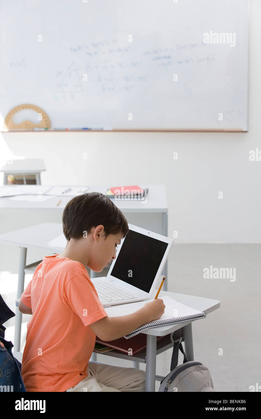 Elementary school student busy doing assignment in classroom Stock ...