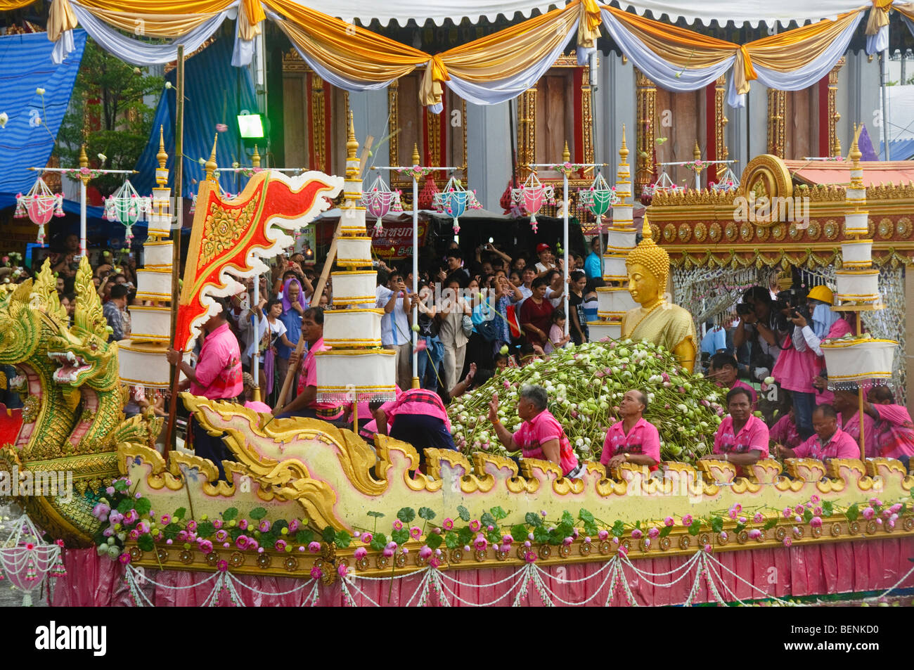 crowds throw lotus flowers at a Buddha image at the Rap Bua Lotus ...