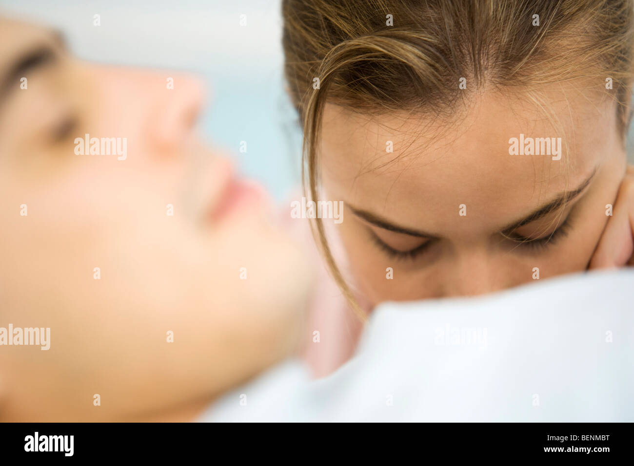 Woman with head down, man asleep in foreground Stock Photo - Alamy