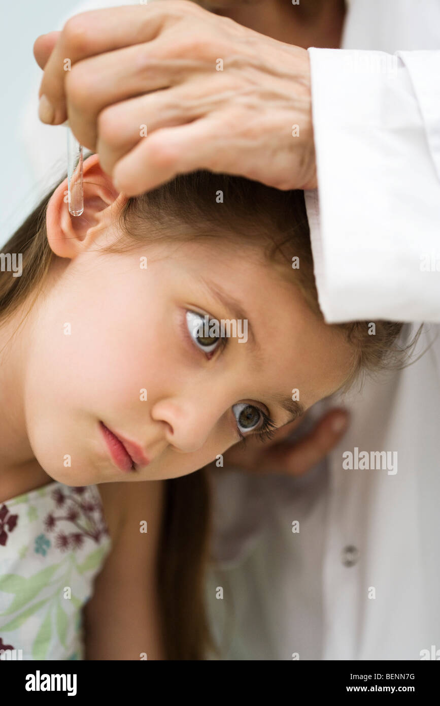 Doctor putting drops in little girl's ear, cropped Stock Photo - Alamy