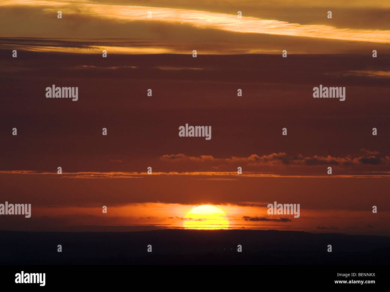 Red disc of sun setting below horizon Stock Photo - Alamy
