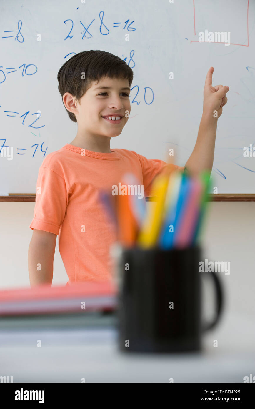 Elementary school student standing in front of class, pointing at ...