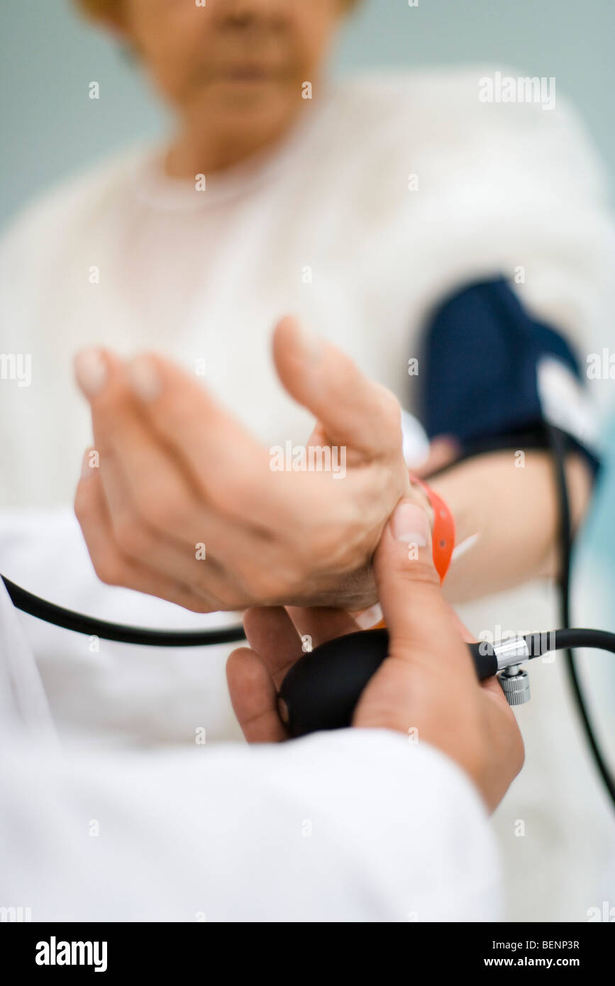 Doctor checking patient's blood pressure, cropped Stock Photo - Alamy
