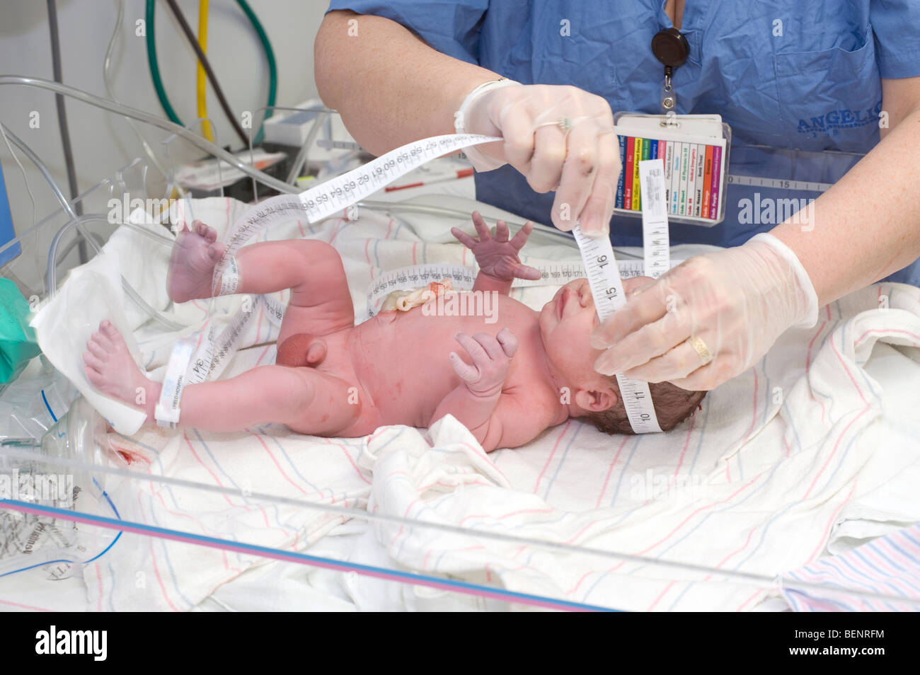 Newborn hispanic boy's head is measured immediately after delivery via ...
