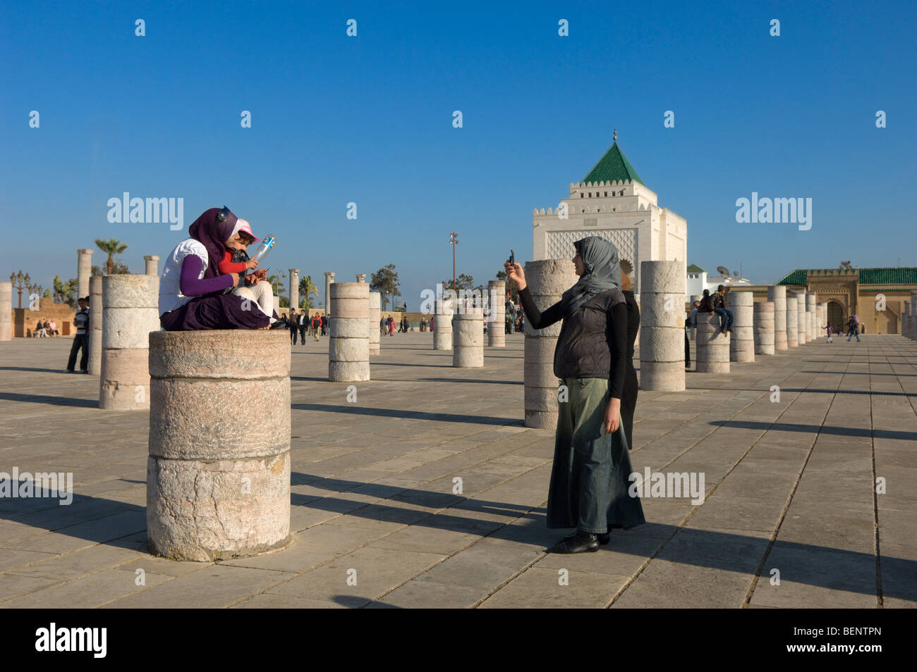 A woman photographs children upon a column in the prayer hall columns ...