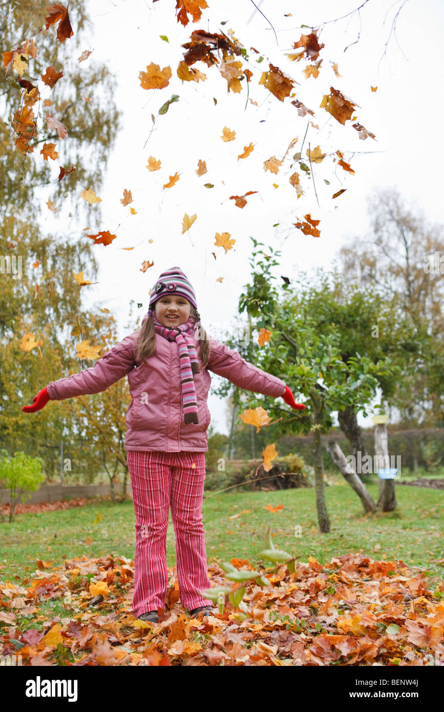 Little girl rake colorful fallen autumn leaves in garden Stock Photo ...