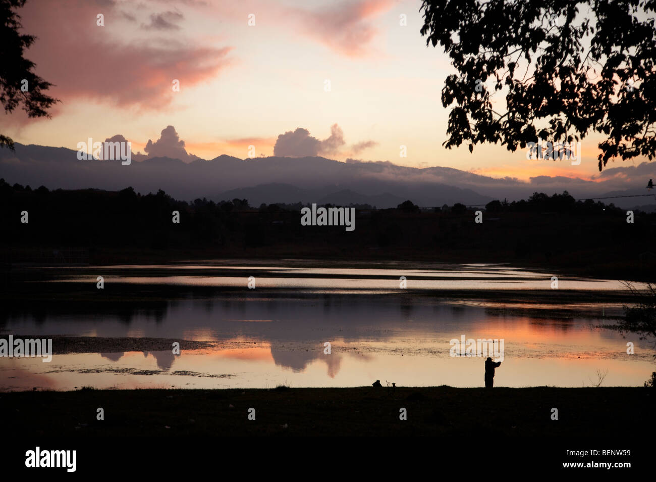 GUATEMALA Sunset over the lake at Lemoa, El Quiche, with a man fishing ...