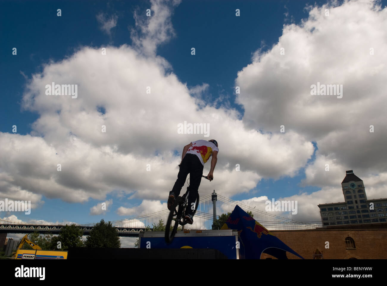 Bicyclist uses his bike to jump up and over and around obstacles in his ...