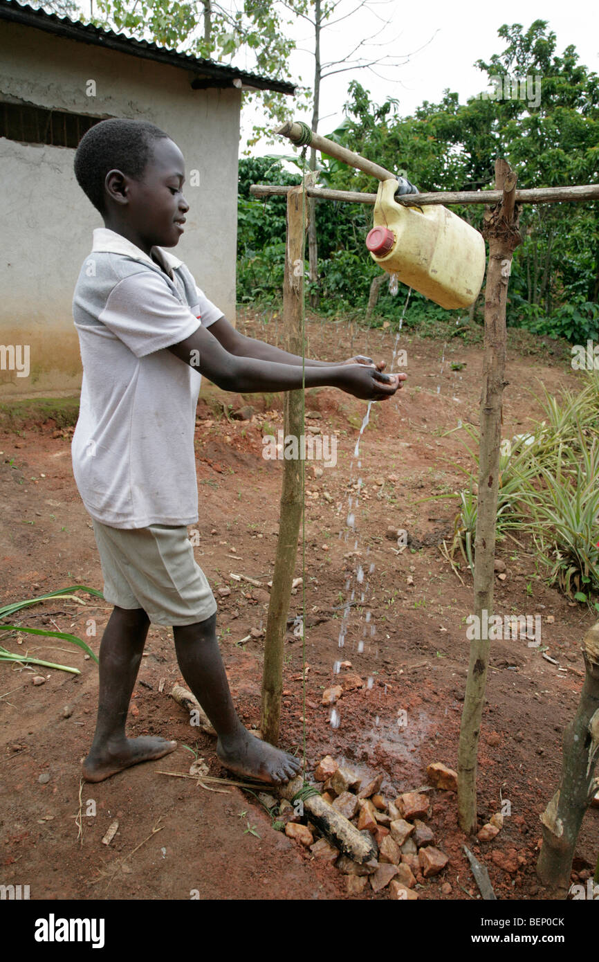 UGANDA Boy using tip-tap, a simple foot-operated hand washing device ...