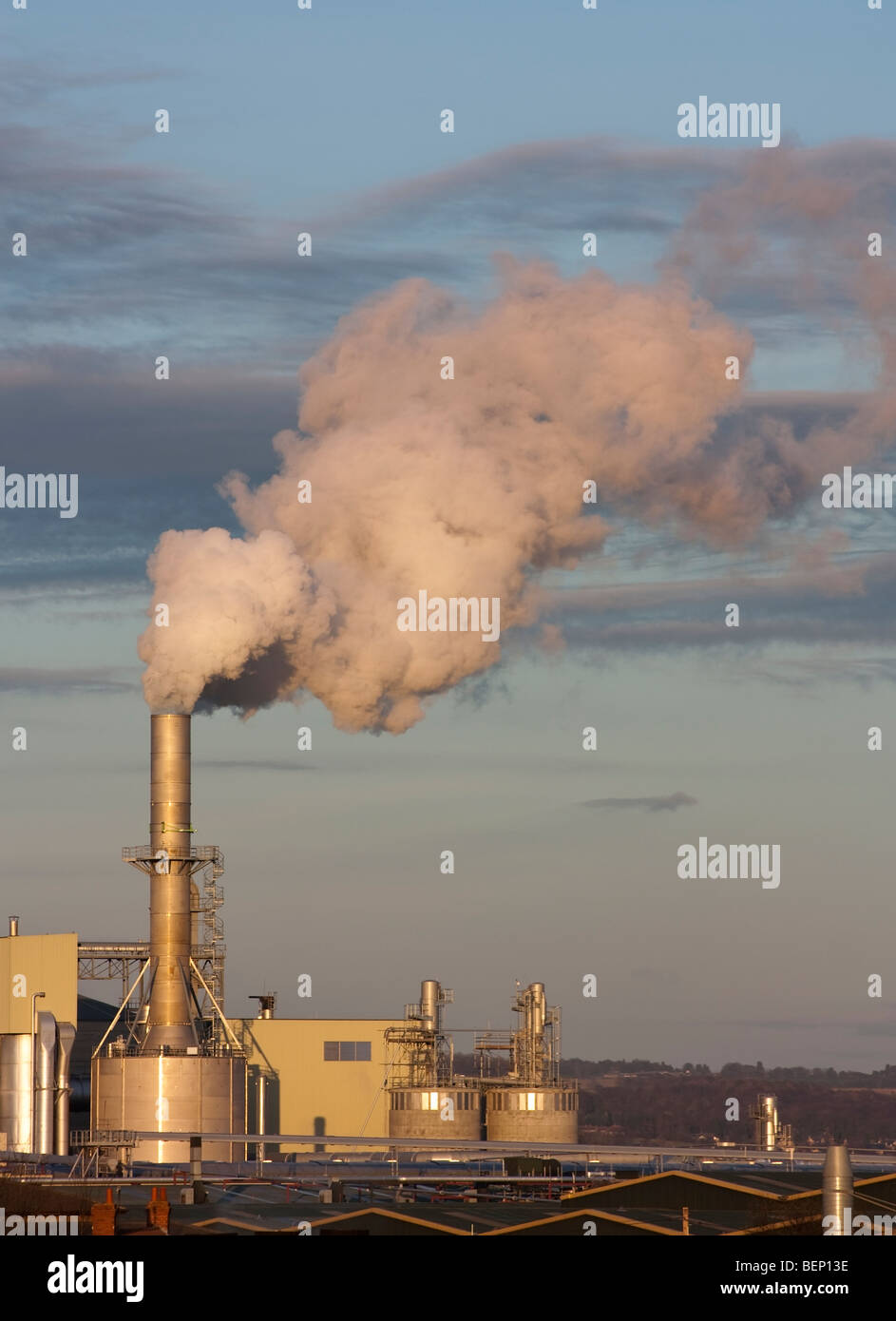 Industrial plant set in rural area spewing out big clouds of steam or ...