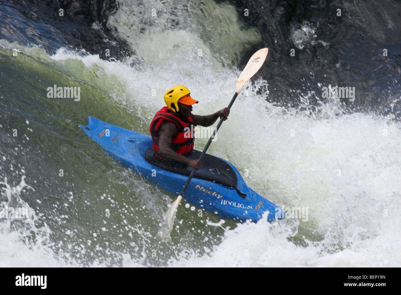 Kayaker in kayak descending waterfall in rapid on the river White Nile ...