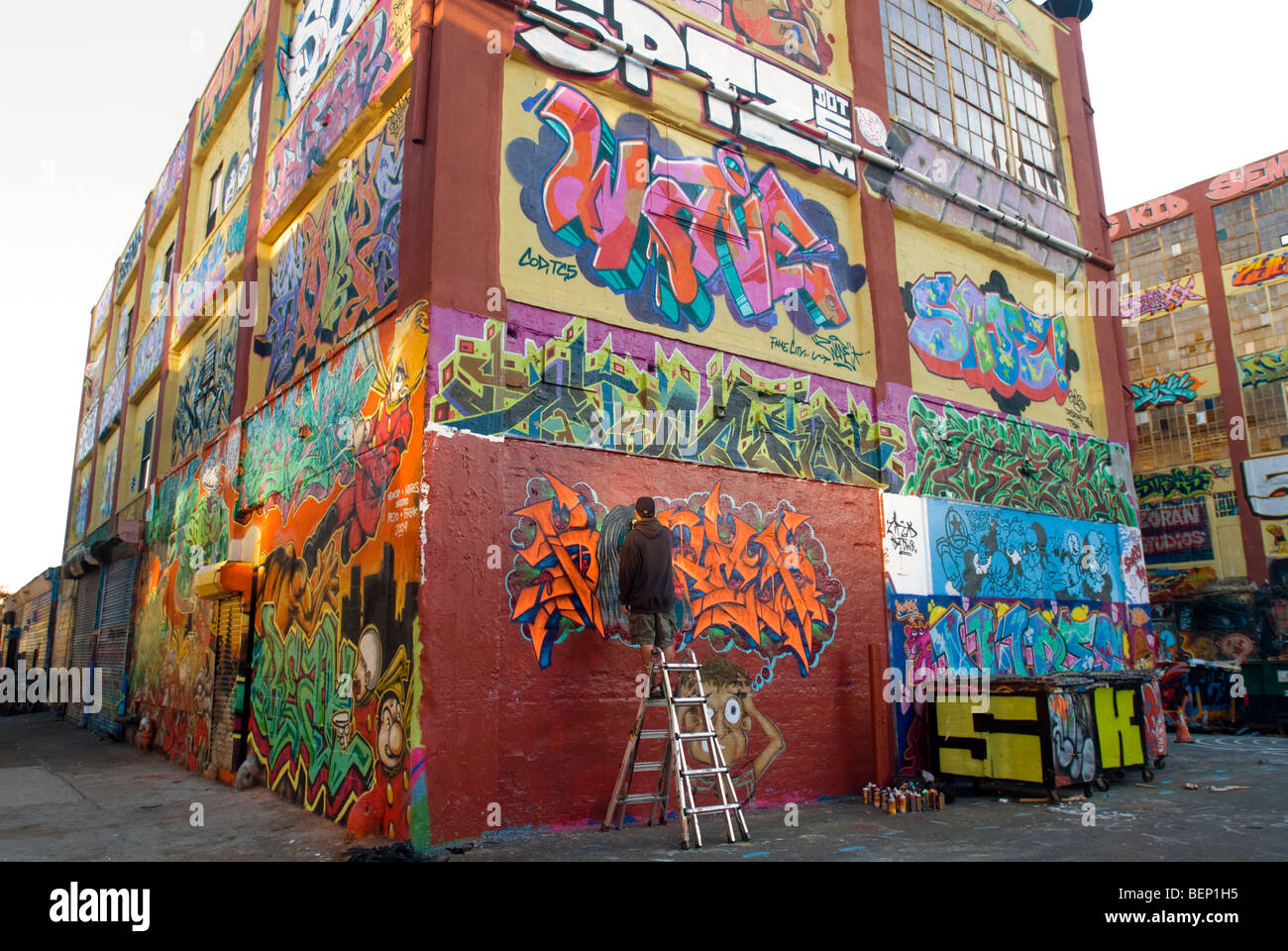 An artist works on his graffiti on the Five Pointz building in Long ...