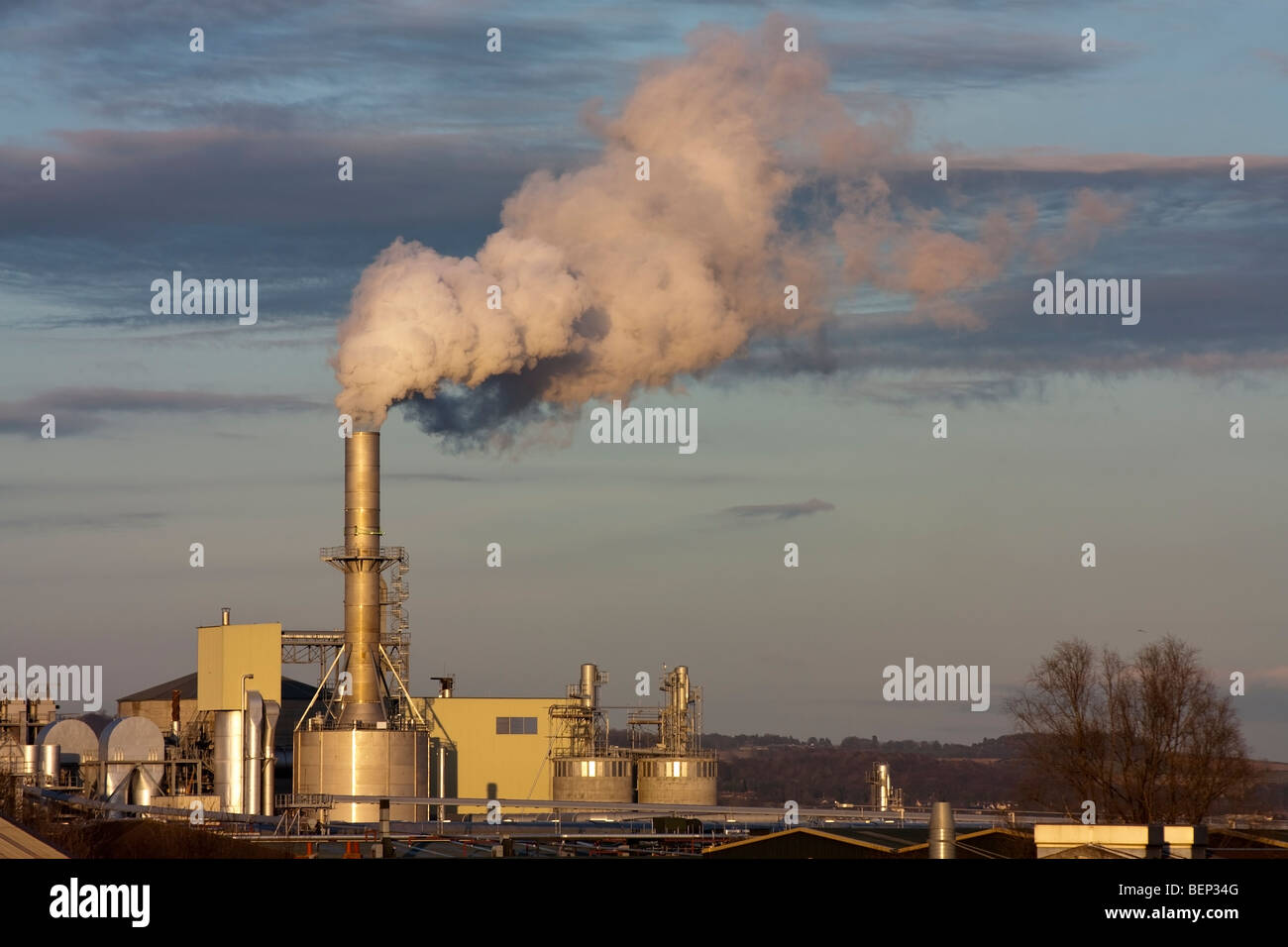 Industrial plant set in rural area spewing out big clouds of steam or ...