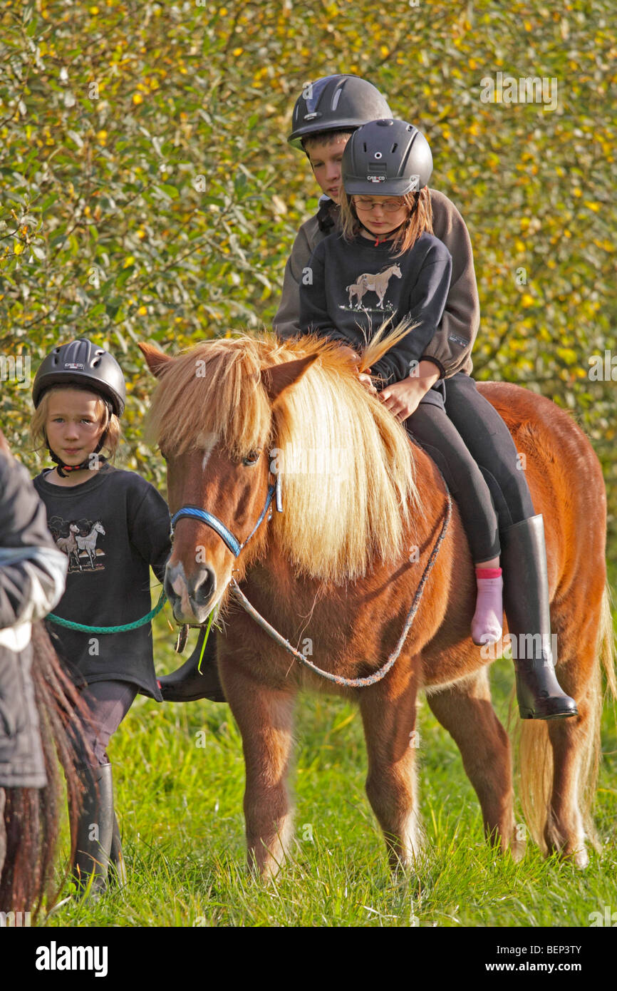 children riding on their ponies through a forest Stock Photo - Alamy