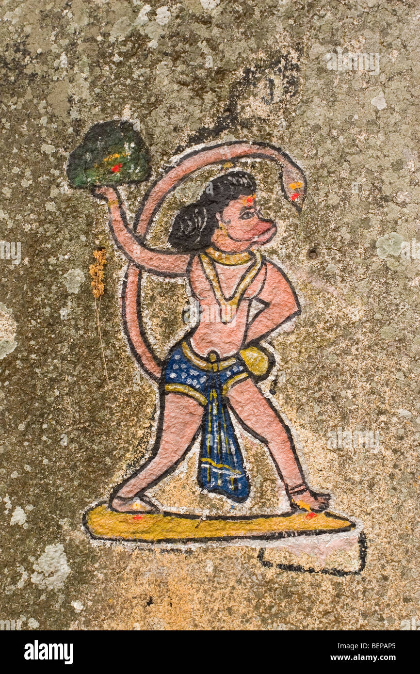 A painted image of the Hindu god Hanuman adorns the stone wall of a ...