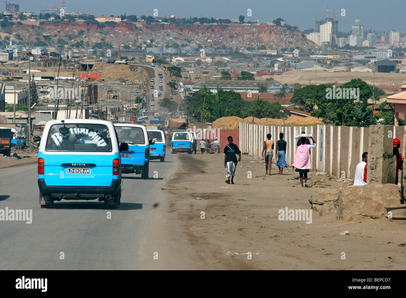 People walking along busy road in suburb of capital city Luanda, Angola ...