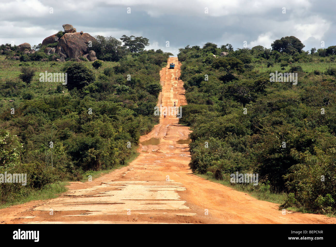 Truck and people walking along dirt road in rural Angola, Southern ...
