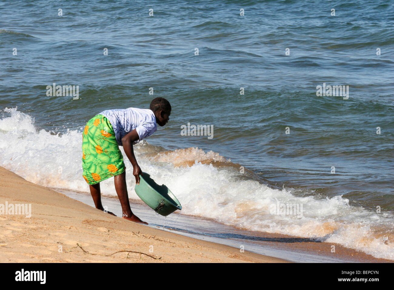 Black woman washing the laundry on the beach along Lake Malawi, Malawi ...