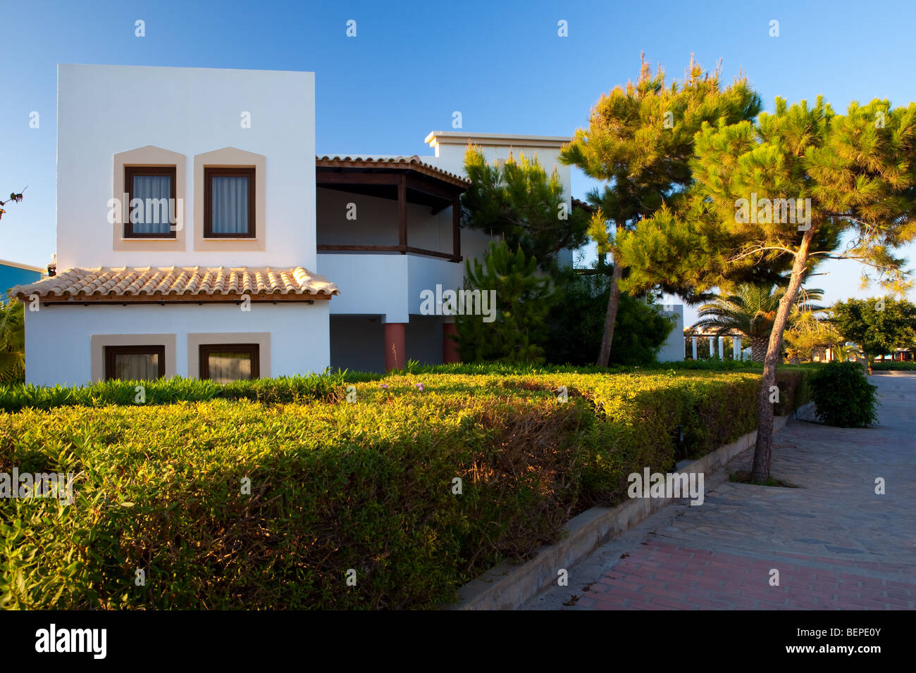 Territory of hotel with a path, palm trees and country houses Stock ...