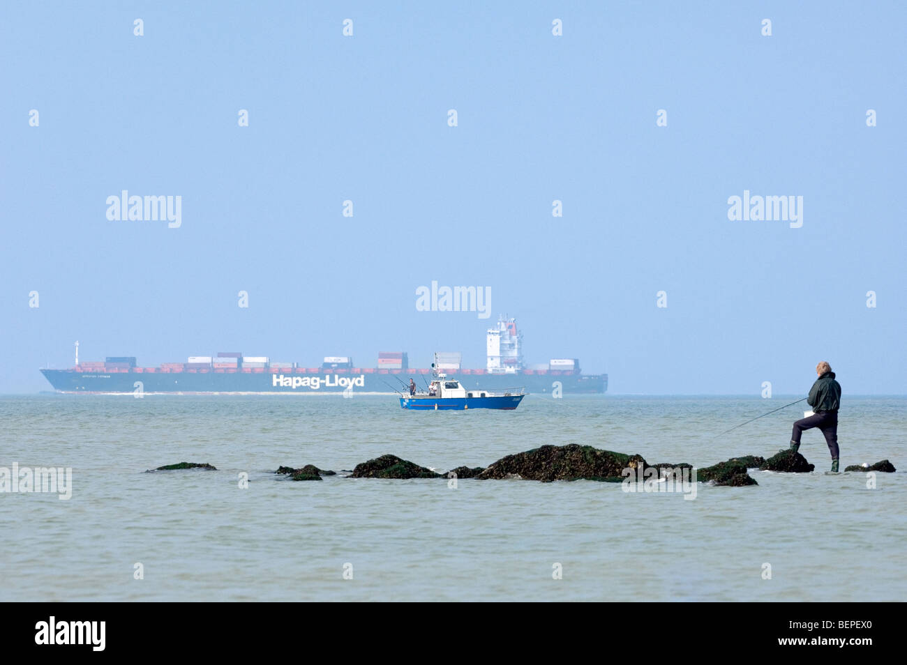Angler, fishing boat and container ship on the North Sea, Belgium Stock ...