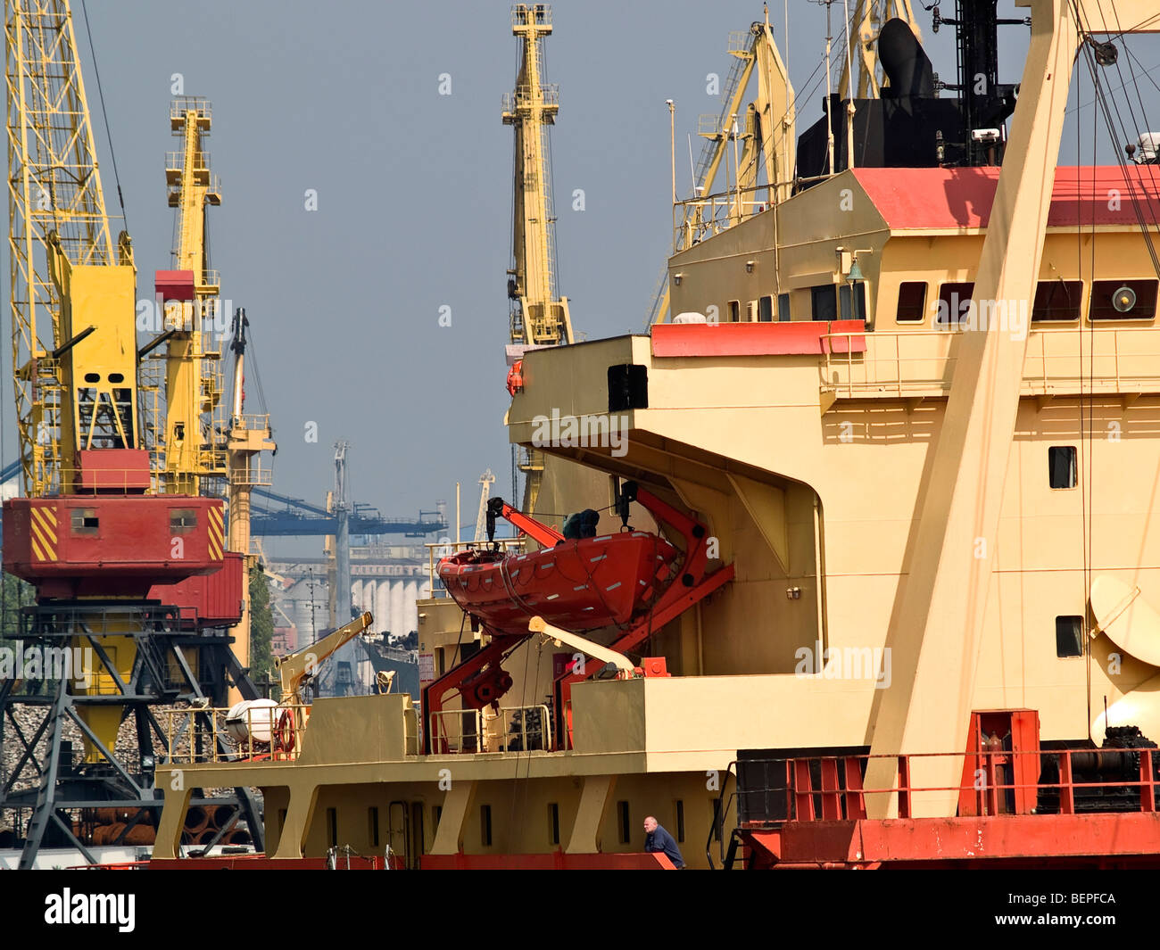 A big vessel in port with cranes on background Stock Photo - Alamy