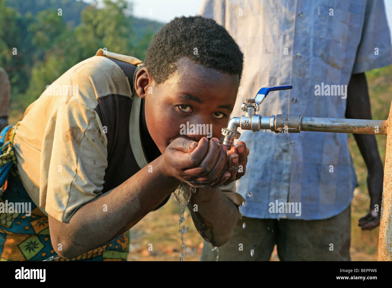 BURUNDI Woman drinking water from a standpipe, Gitera. PHOTOGRAPH by ...