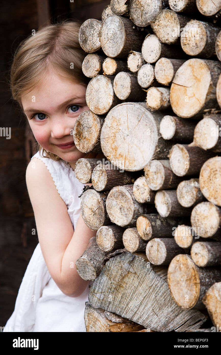 Girl hiding behind logs Stock Photo - Alamy