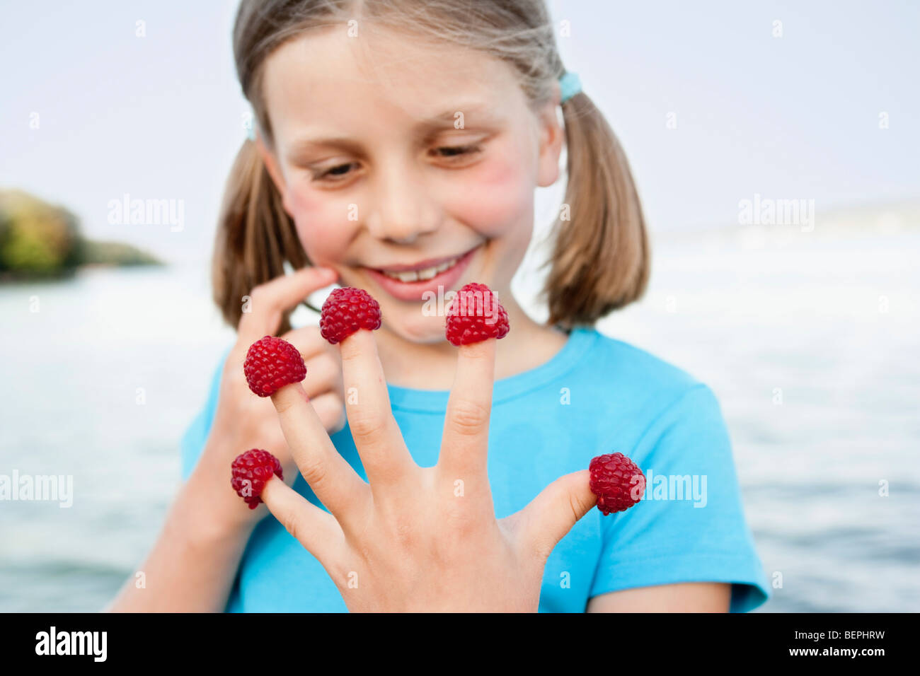 Young Girl Eating Raspberries Stock Photo - Alamy