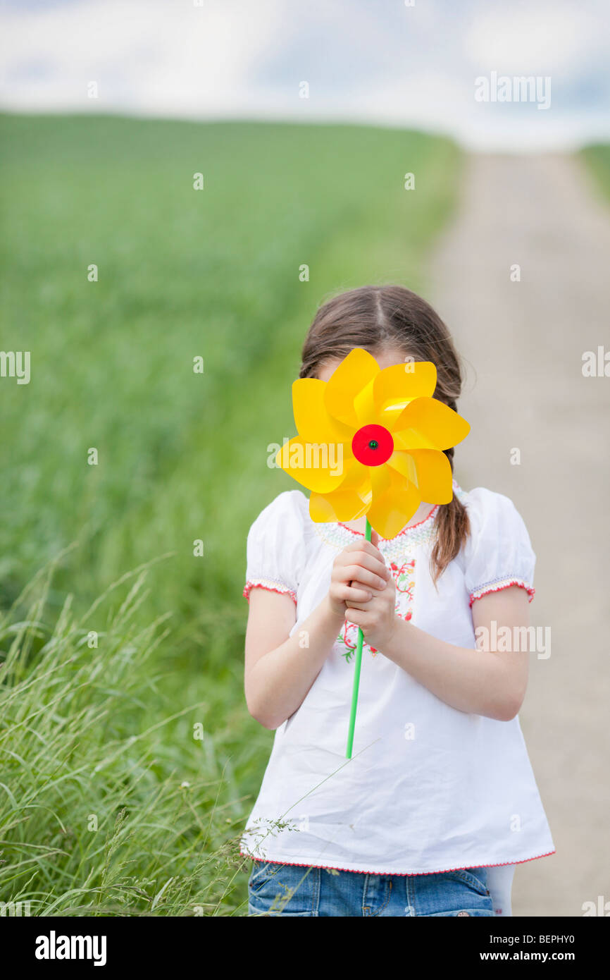 young girl playing with toy windmill Stock Photo - Alamy