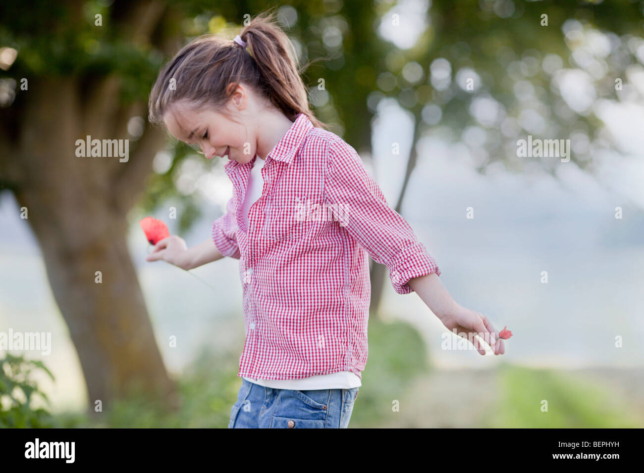 young girl playing with flowers Stock Photo - Alamy