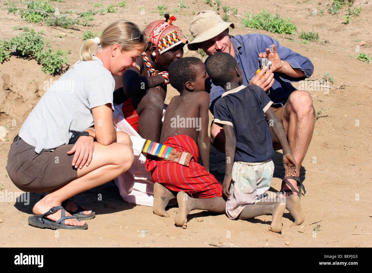 Tourists meeting curious Turkana children in traditional red clothing ...