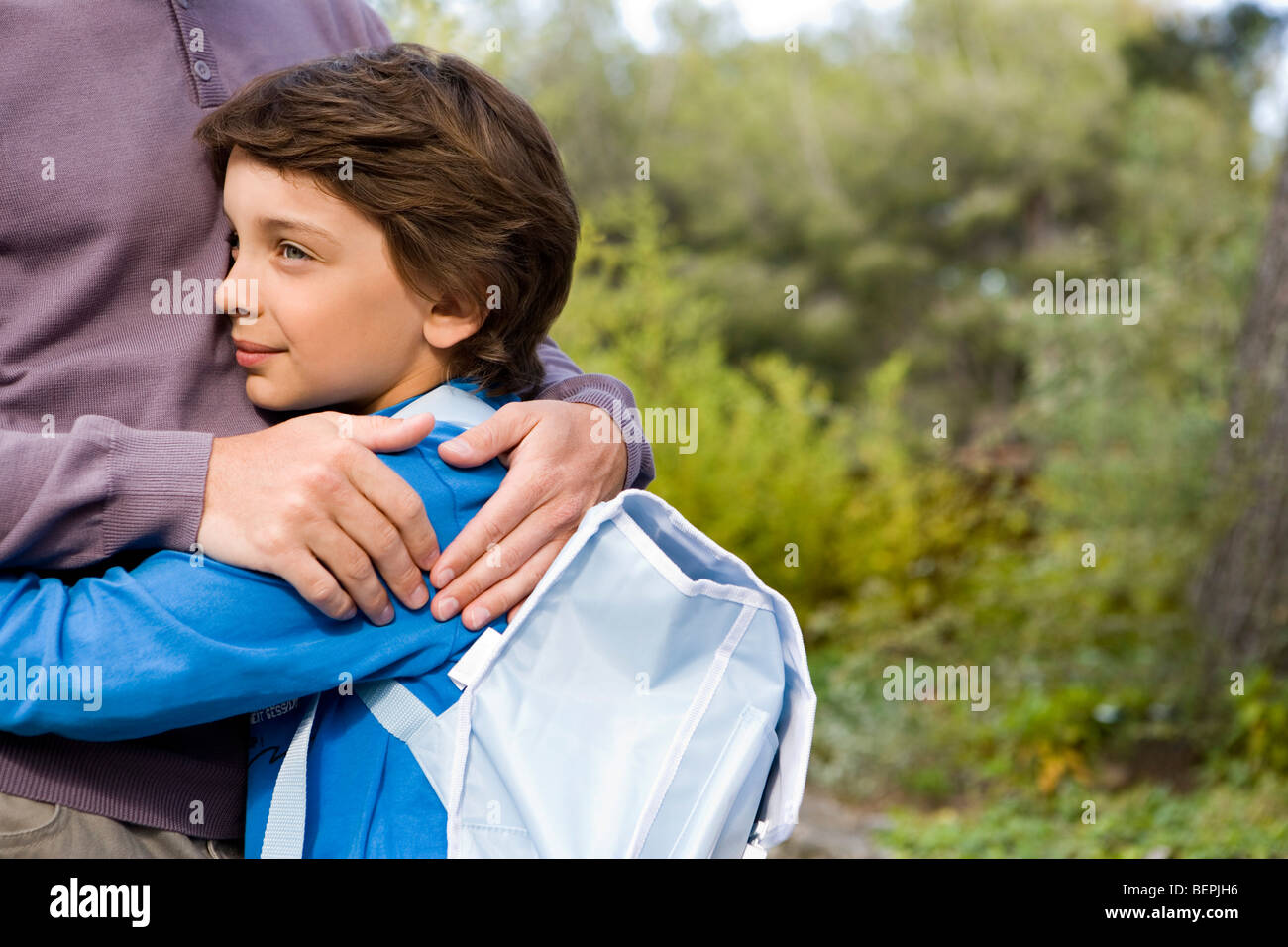 boy cuddling dad back from school Stock Photo - Alamy