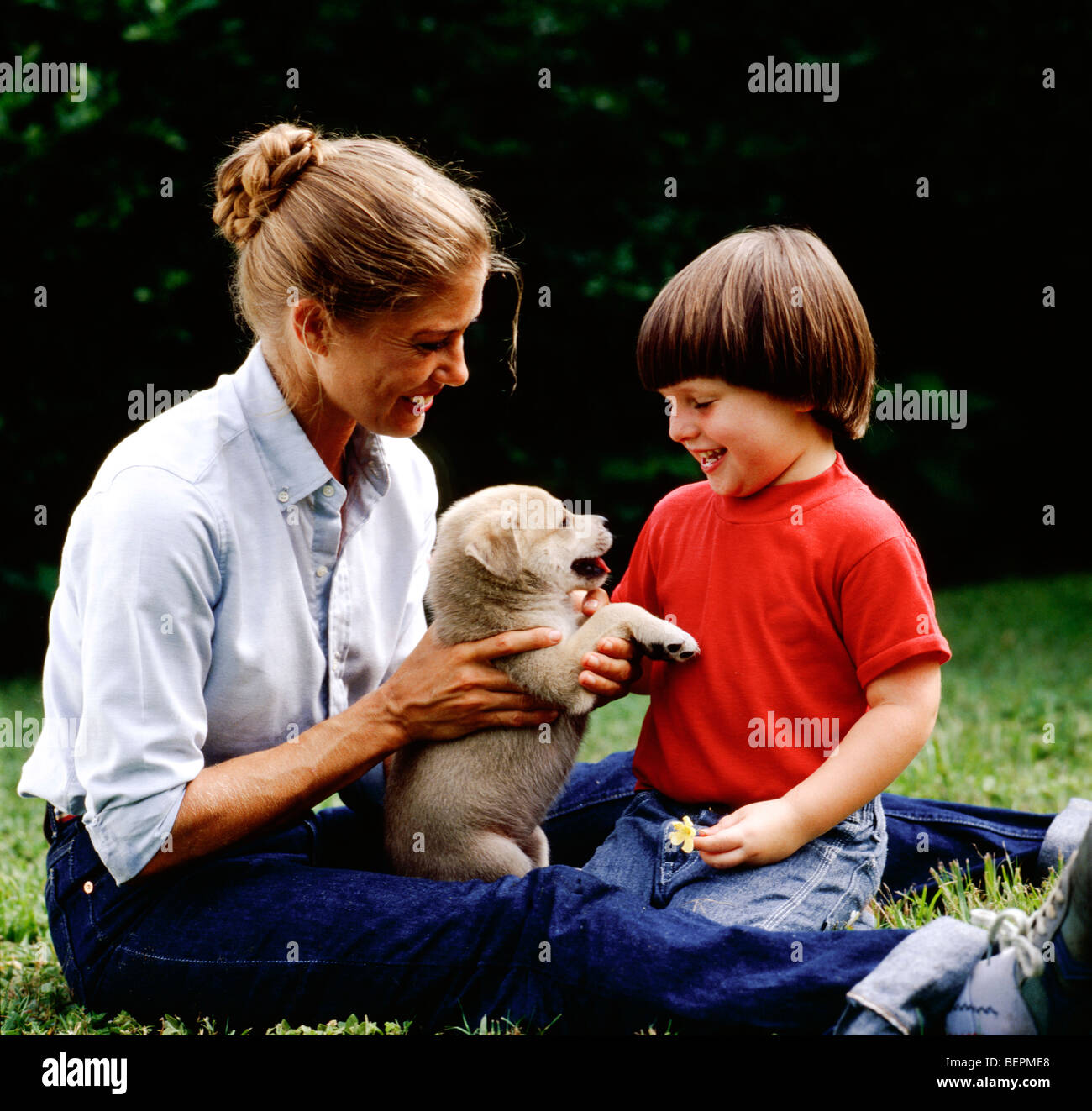 Mother and child with puppy Stock Photo - Alamy