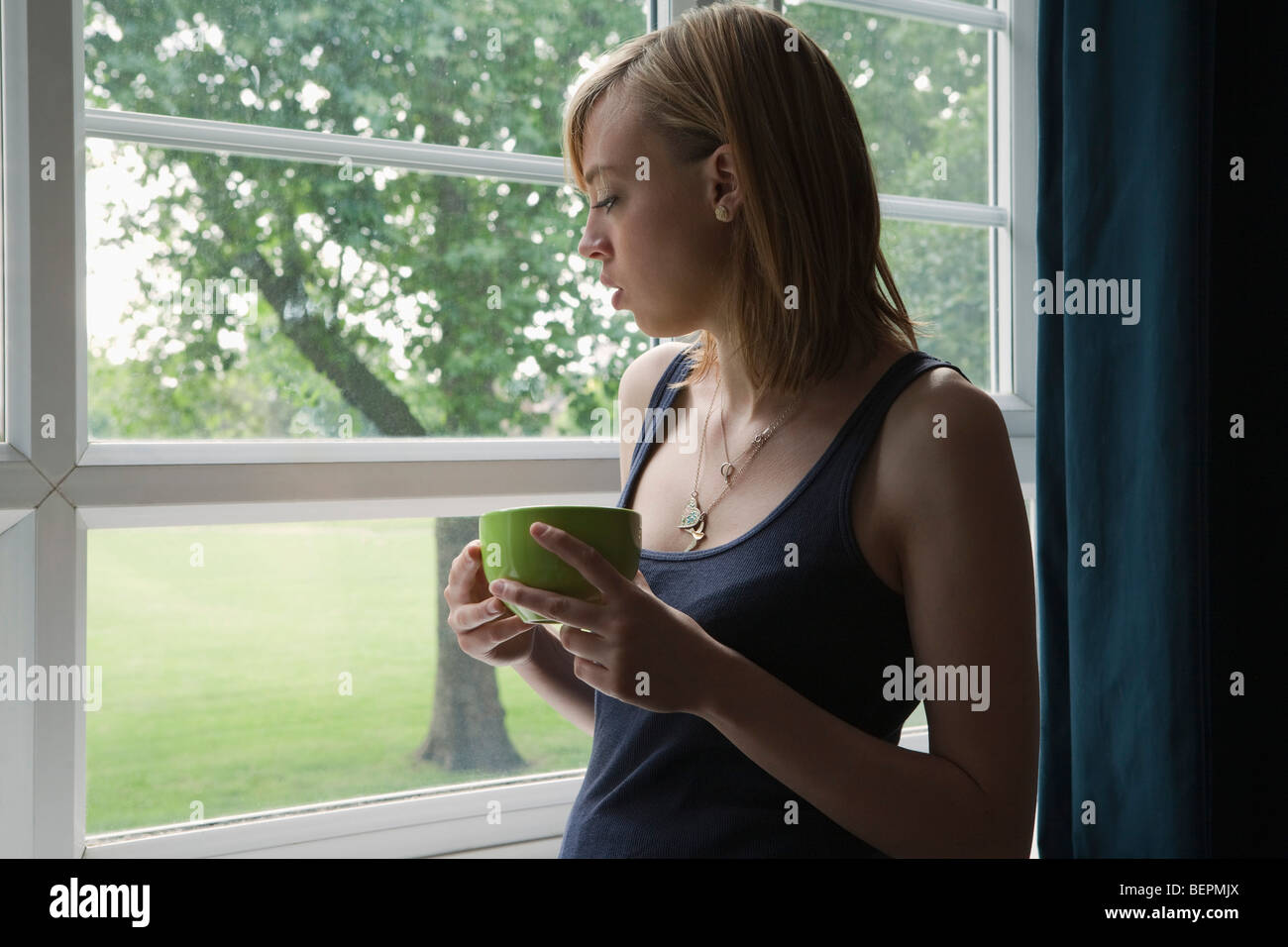 Woman looking out of window Stock Photo - Alamy