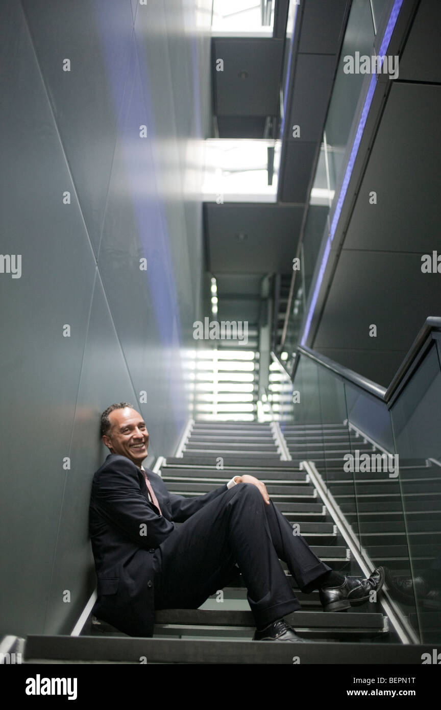 man sitting on stair steps smiling Stock Photo - Alamy