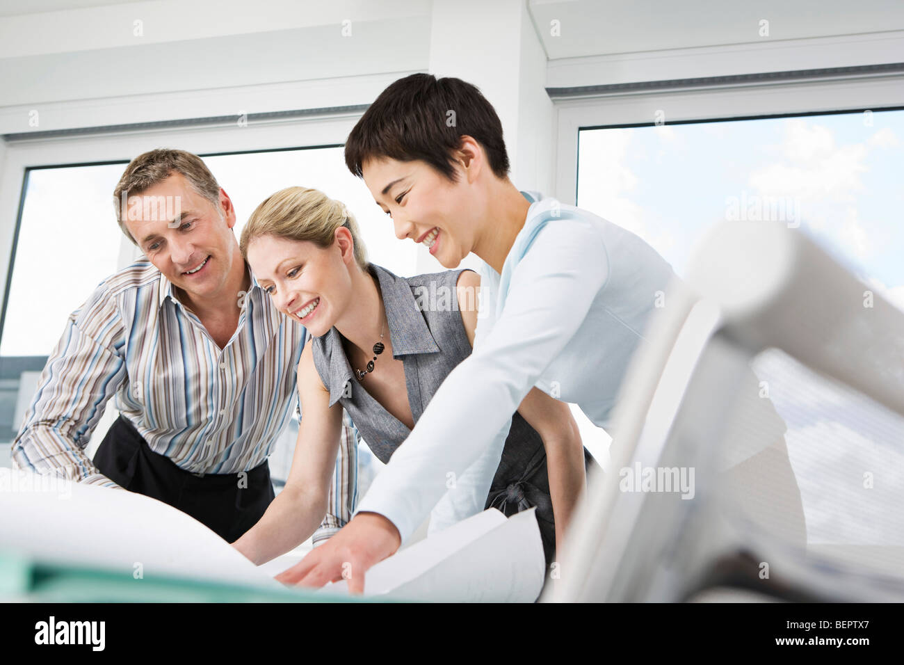 Three business people look plans hi-res stock photography and images ...