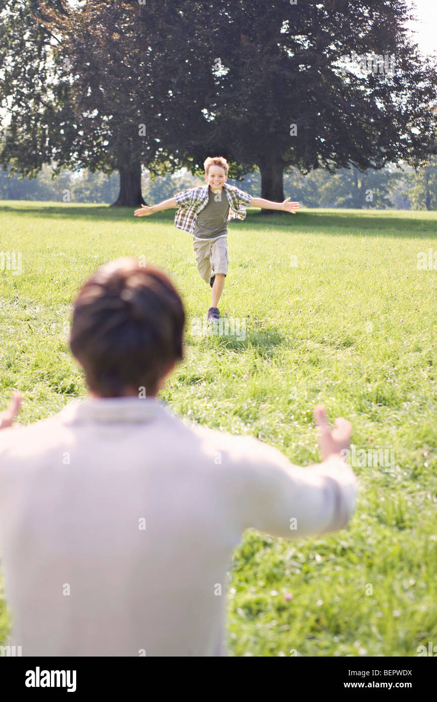A boy running to his father in the park Stock Photo - Alamy