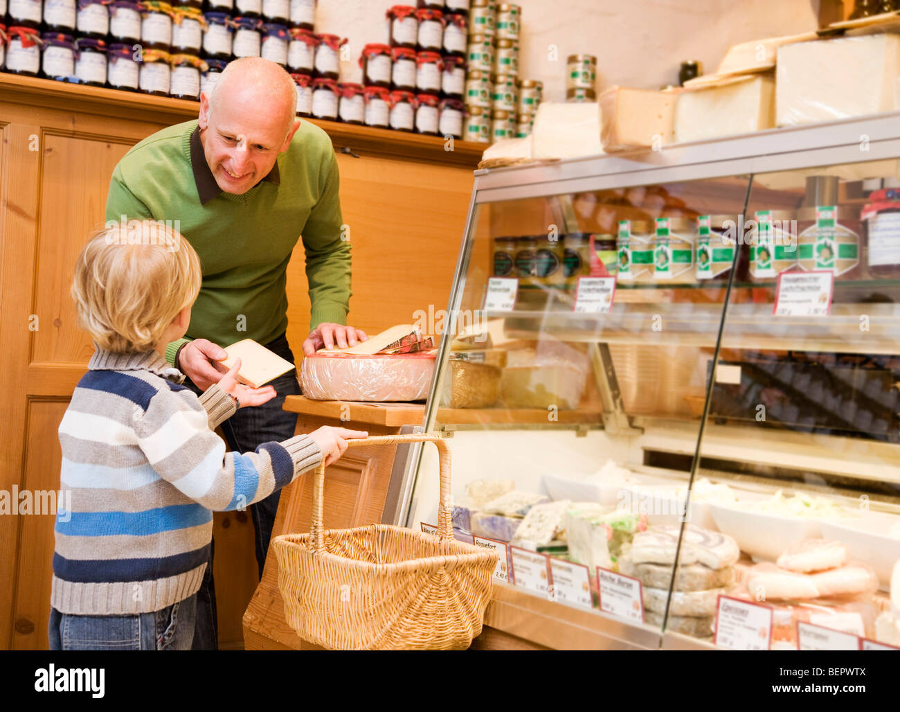 cheese store owner with boy in shop Stock Photo - Alamy