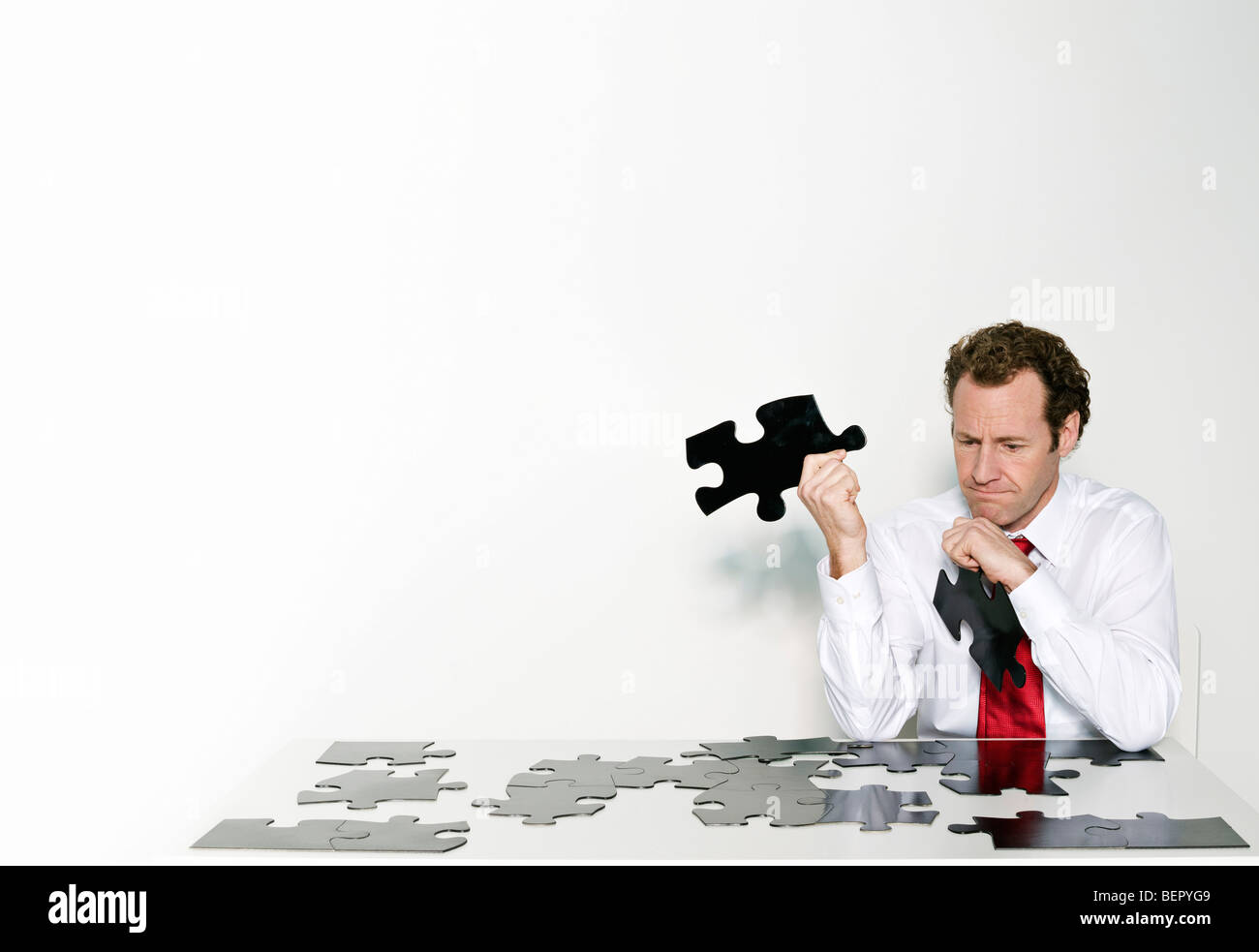 A business man doing a jigsaw Stock Photo - Alamy